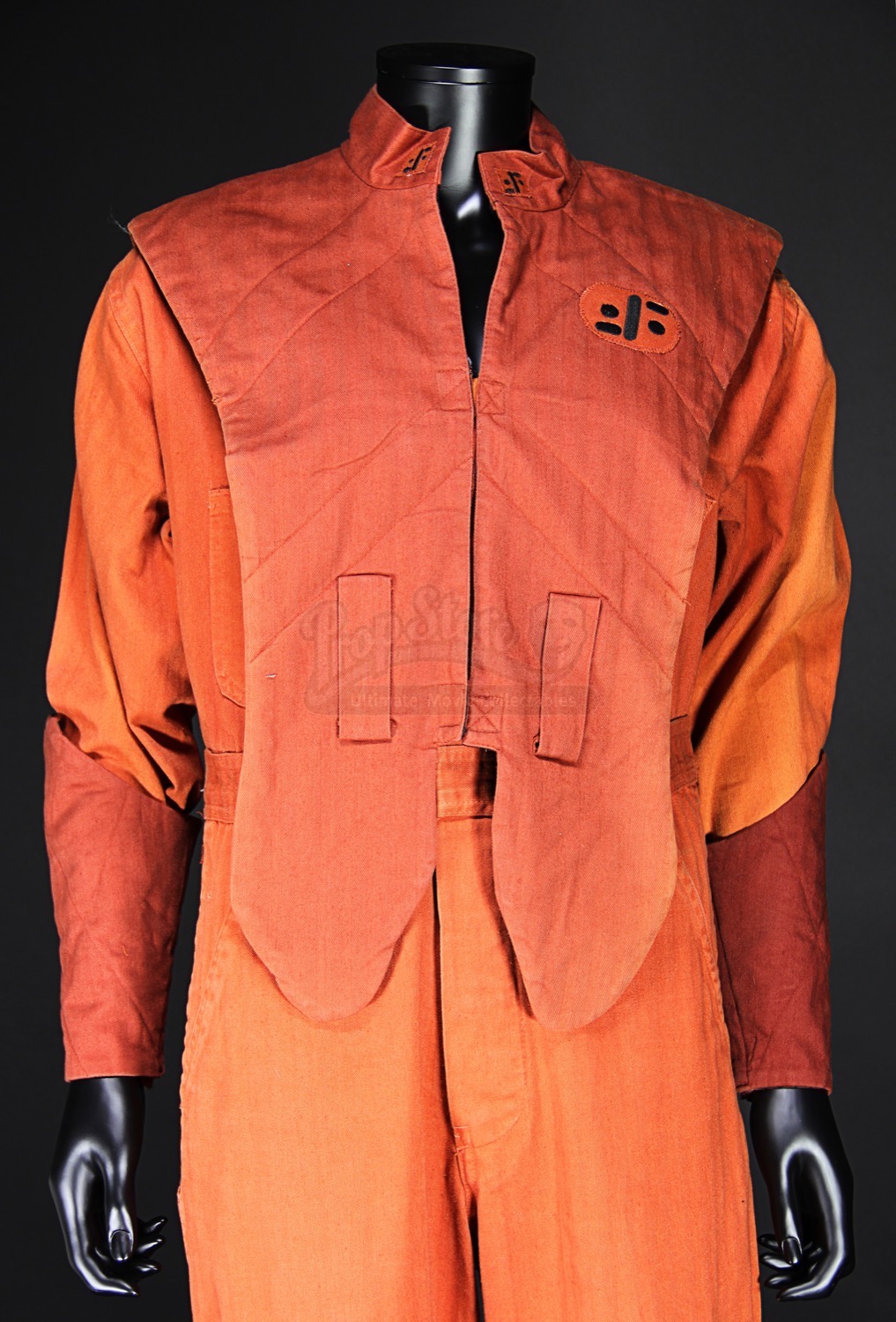 While the costume shows significant fading, particularly on thejumpsuit ...