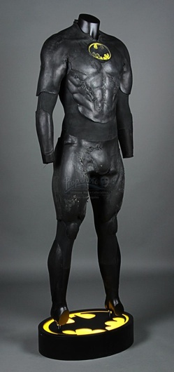 Batman’s (Michael Keaton) battledamagedbatsuit and chest emblem fromTim ...